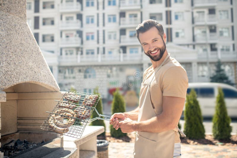 Handsome Man is Grilling Delicious Food on Grill for His Friends at ...