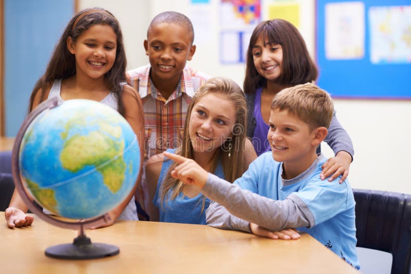 Enjoying Geography. a Group of Students Looking at a Globe during ...