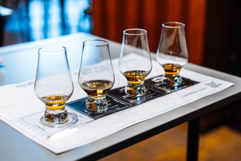 Enjoying Whiskey Tasting with Four Glasses and Tasting Notes on a Table ...