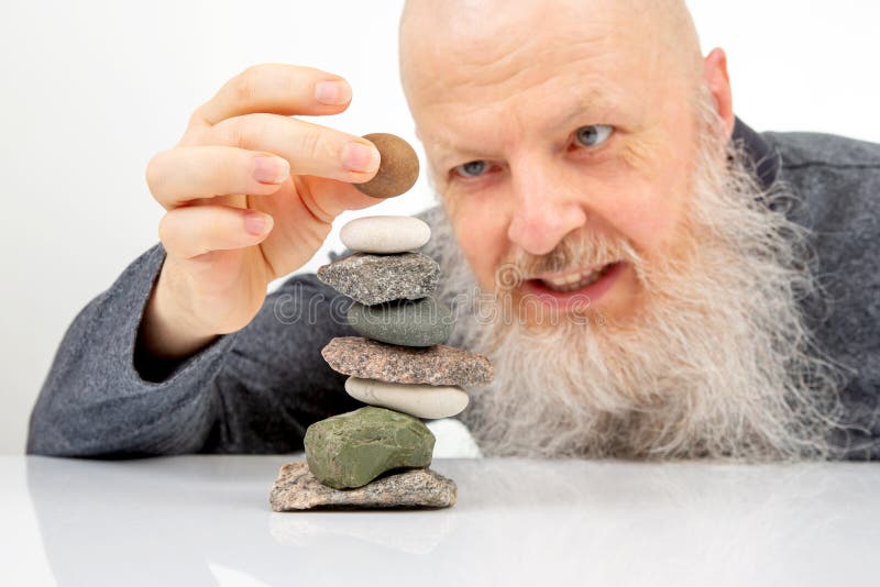 Enthusiastic Older Man Smiling Widely while Engaged in Building a Stack ...