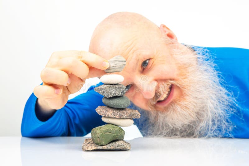 Enthusiastic Older Man Smiling Widely while Engaged in Building a Stack ...
