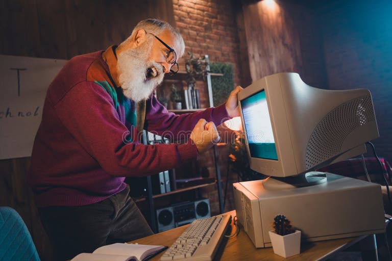 Enthusiastic Senior Man Using a Desktop Computer at Home Office Engaged ...