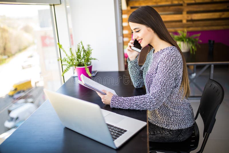 Entrepreneur Calling on Phone and Working on Line with a Laptop Sitting ...