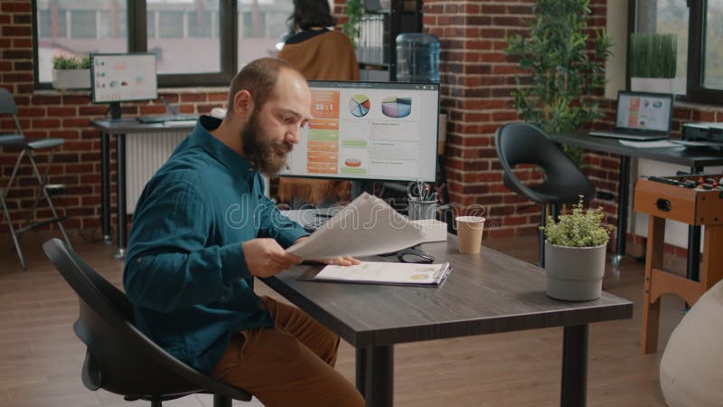 Entrepreneur Looking at Papers and Computer with Rate Charts Stock ...