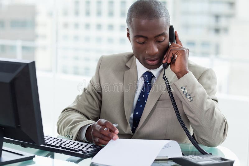 Entrepreneur Making a Phone Call while Reading a Document Stock Photo ...