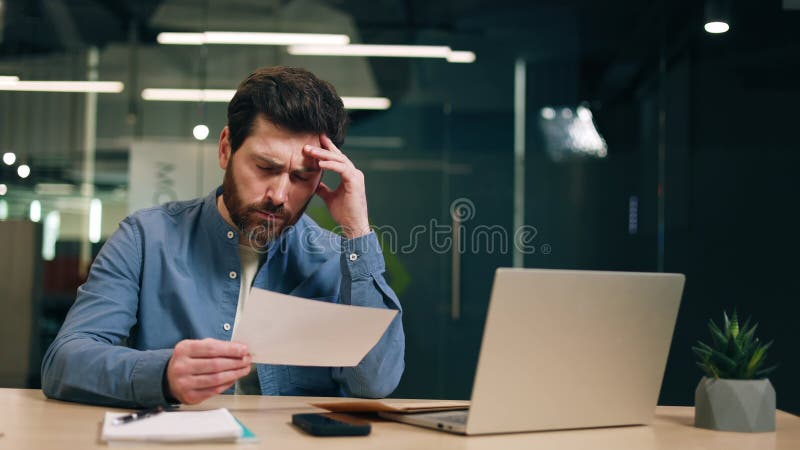 Male Entrepreneur Reading Document and Expressing Concern while Sitting ...