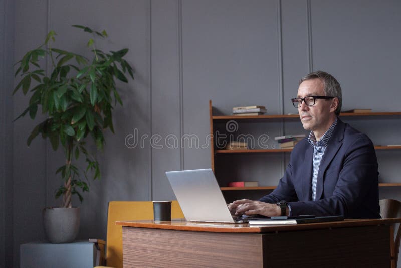 Entrepreneur Sitting at Office Desk and Reading an E-mail while Working ...