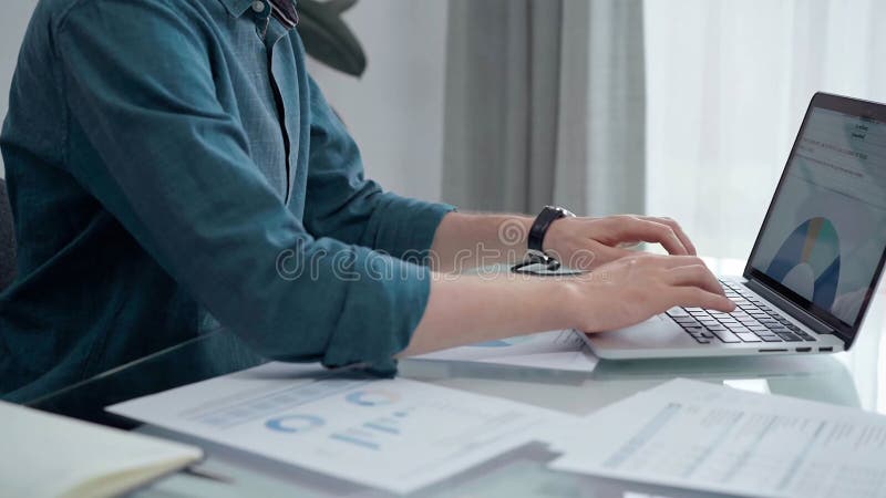 Entrepreneur Wearing Green Shirt is Working at Laptop with Data ...