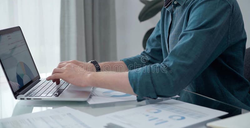 Entrepreneur Wearing Green Shirt is Working at Laptop with Data ...
