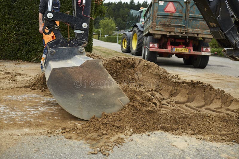 Construction Workers Digging Up Dirt with Machine Stock Photo - Image ...