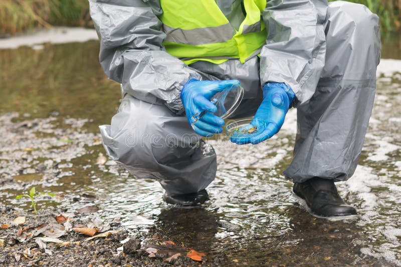 An Environmental Laboratory Specialist in a Protective Suit Lids a ...