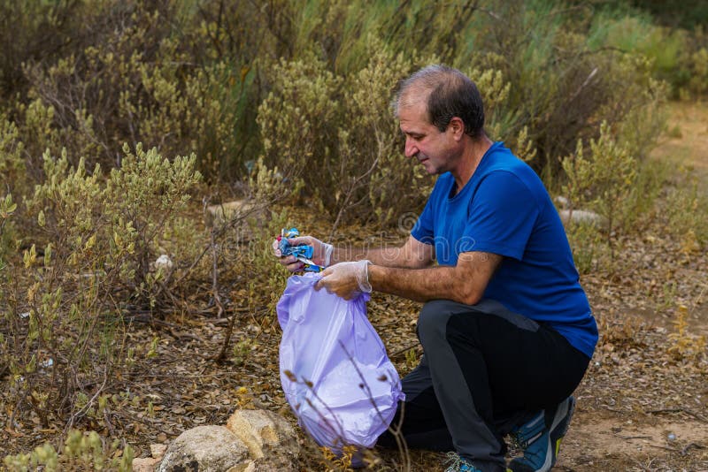 Environmentalist Man Picking Up Garbage from the Field Stock Photo ...