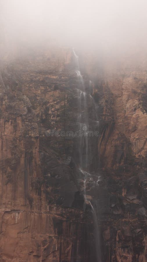Ephemeral Waterfall on Sandstone Cliff with Low Clouds Stock Image ...