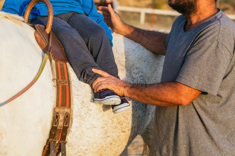 Equine Therapy Instructor Helping a Kid with Disabilities on the Horse ...