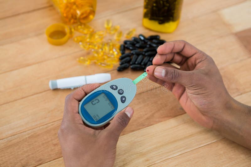 Equipaggia La Glicemia Di Prova Della Mano Con Il Glucometer Immagine ...