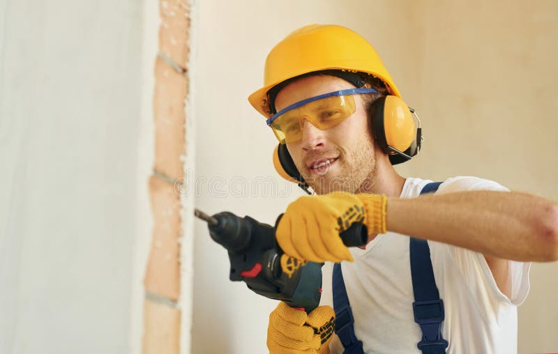 With Equipment. Young Man Working in Uniform at Construction at Daytime ...