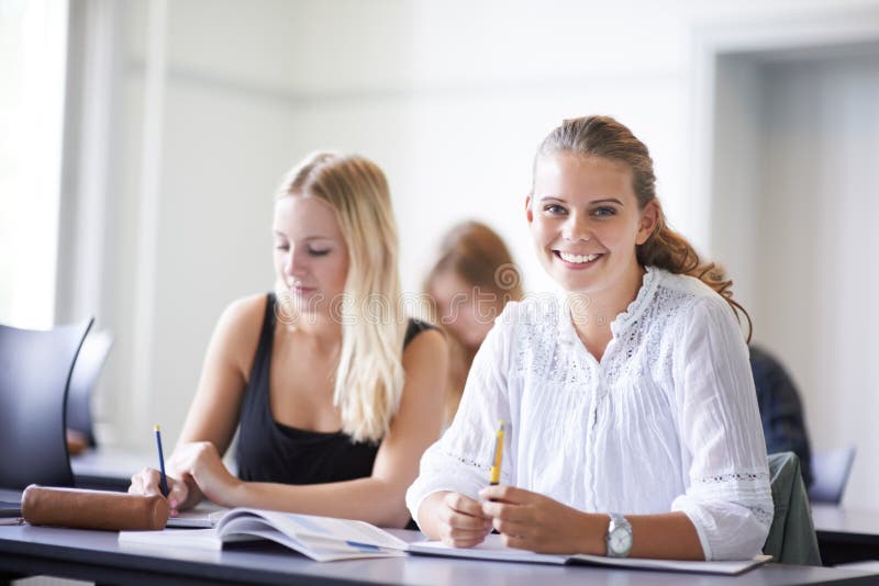 Es Un Estudiante. Una Adolescente Sonriente Sentada En Un Aula. Imagen ...