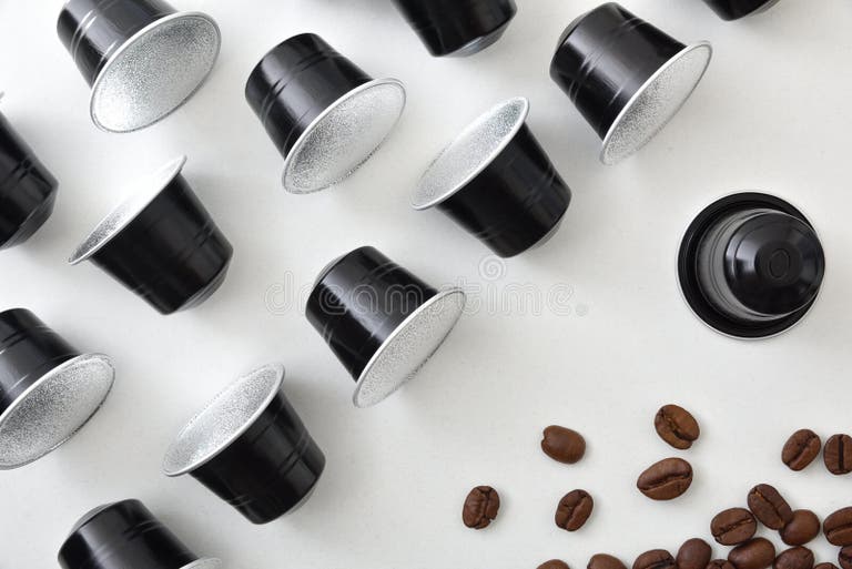 Espresso Coffee Capsules in Rows and Beans on White Table Stock Photo ...