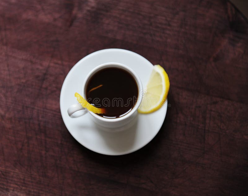 Espresso Romano Coffee with Lemon in a White Cup on a Dark Wooden Table ...