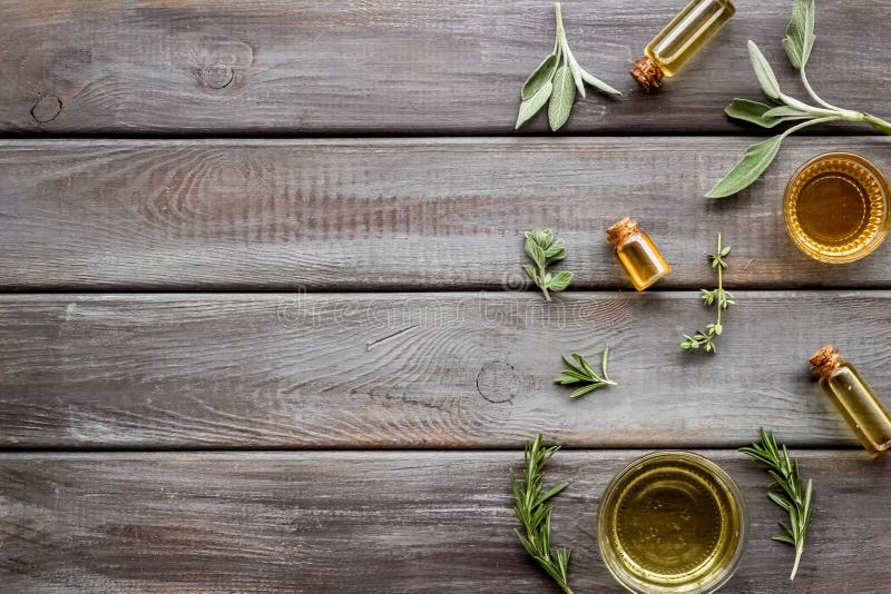 Essential Oils and Fresh Herbs on Dark Wooden Background Top View ...