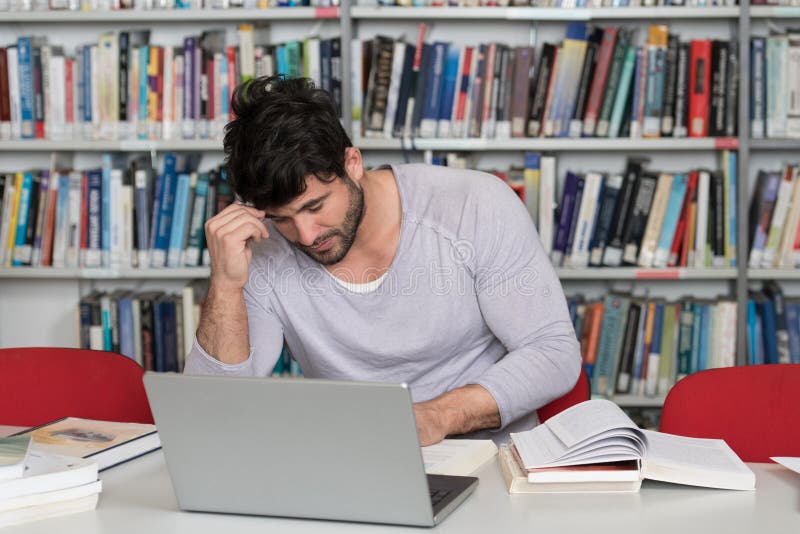 Estudiante Cansado Working with Laptop En La Biblioteca Imagen de archivo - Imagen de aprendiz ...