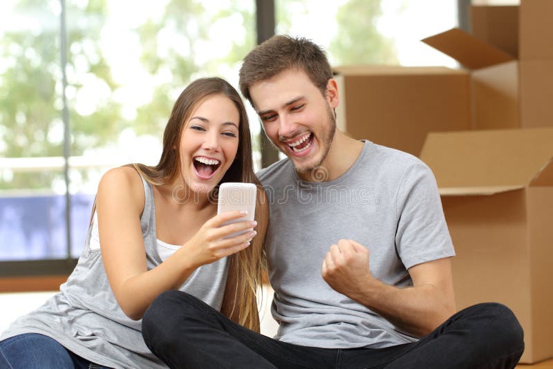 Euphoric Couple Moving House and Watching Phone Stock Image - Image of ...