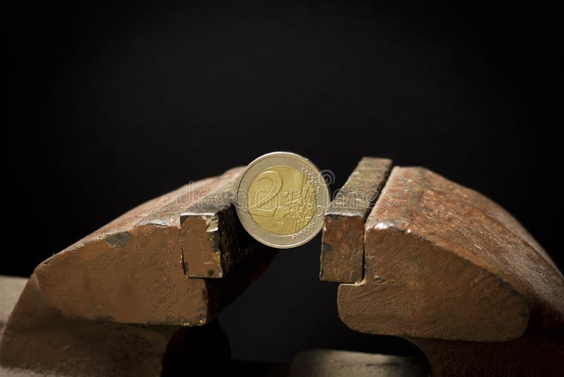 2 Euro Coin in a Metal Vise. Concept of Economic Problems. Selective ...