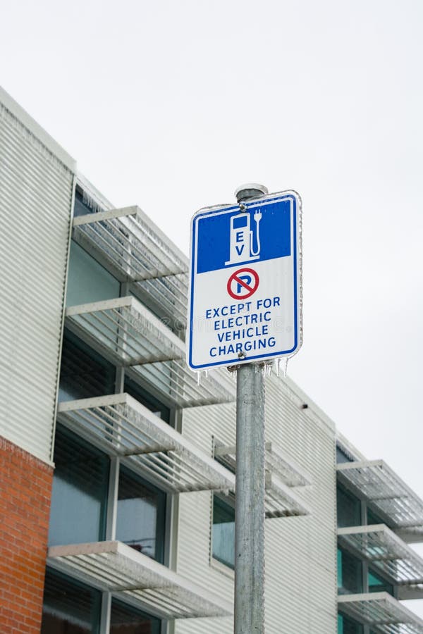 EV Charging Station Sign in Icicles with Office Building on the ...