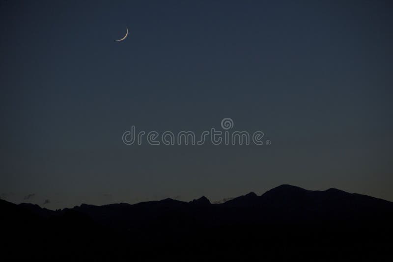 Evening Crescent Moon in the Shadow of the Mountains Stock Image ...