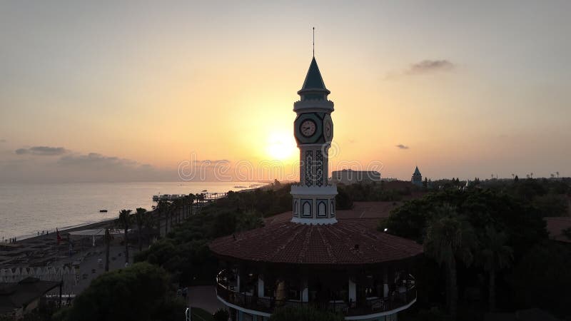 Evening Drone Flight Over Clock Tower at Sunset with Beach, Mountains ...
