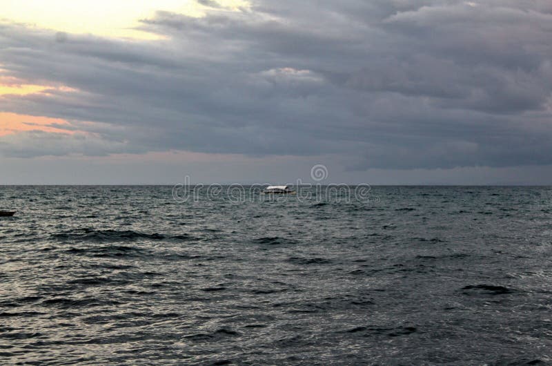 Evening Gray Sea with a Small Boat in the Distance Stock Image - Image ...