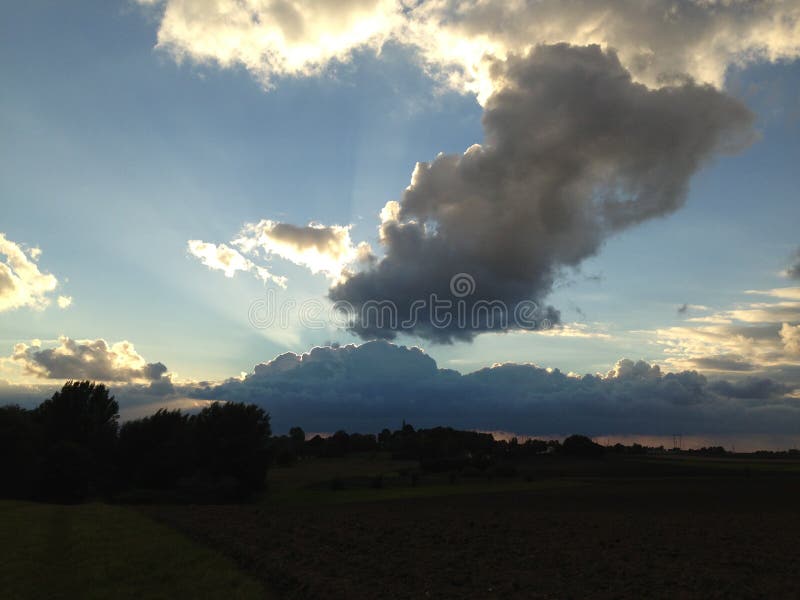 Evening Sun Behind Beautiful Large Clouds Over Dark Fields Stock Photo ...