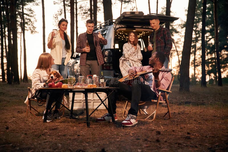 Evening Time, by the Table. Group of Friends are Together in the Forest ...