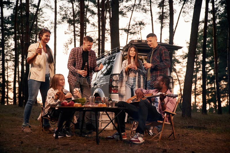 Evening Time, by the Table. Group of Friends are Together in the Forest ...