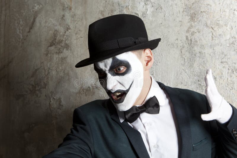 Evil Clown Wearing a Bowler Hat on Wall Background Stock Photo - Image ...