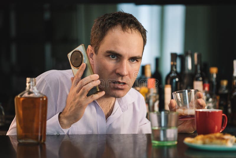 An Evil Drunk Businessman Talking on Phone while Holding a Glass of ...
