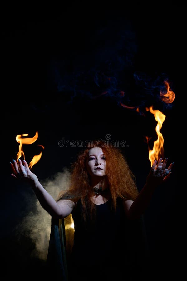 An Evil Red-haired Witch Holds Fire in Her Hands. Stock Photo - Image ...