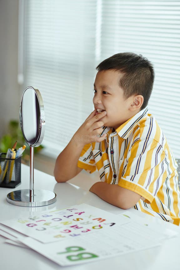 Examining Reflection in Mirror at Study Desk Stock Photo - Image of ...