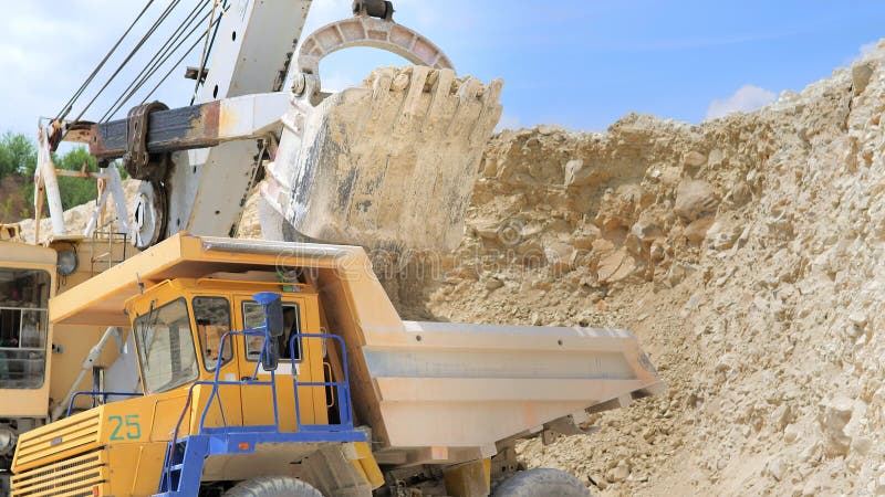 An Excavator in Action on a Construction Site. an Excavator and a Truck ...