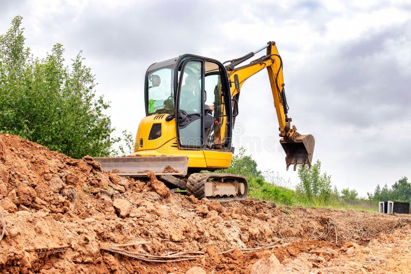 A Excavator Actively Digging through a Mound of Soil and Dirt, Creating ...