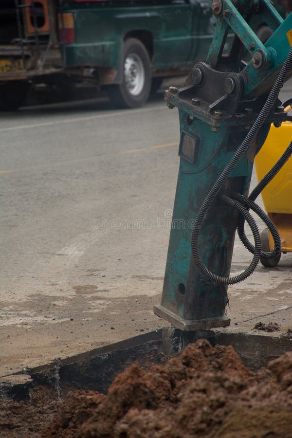 Excavator Breaking and Drilling the Concrete Road for Repairing. Large ...