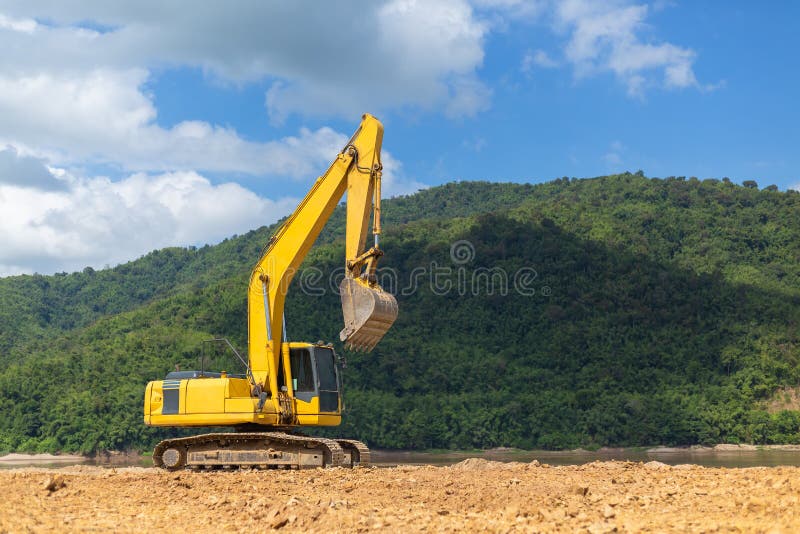 Excavator in Construction Equipment Site on River and Mountain and Sky ...