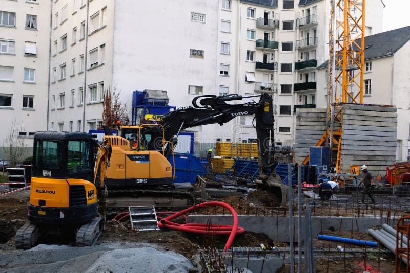 Construction Machine with a Building Under Construction with Workers ...