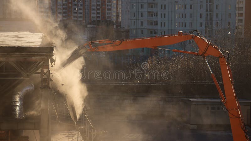 Excavator Demolition Arm in Sunlit Dust Cloud Dismantles the Building ...
