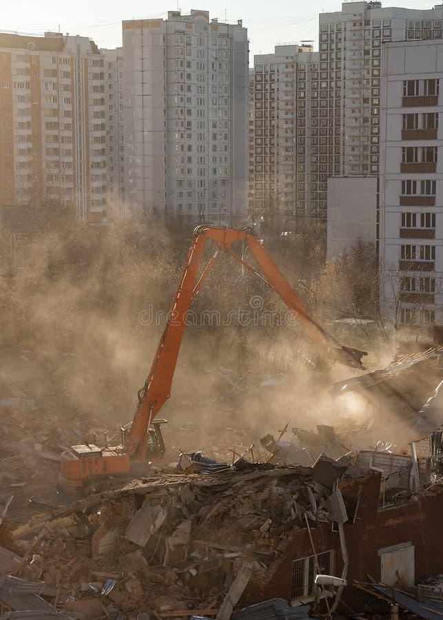 Excavator Demolition Arm in Sunlit Dust Cloud Dismantles the Building ...