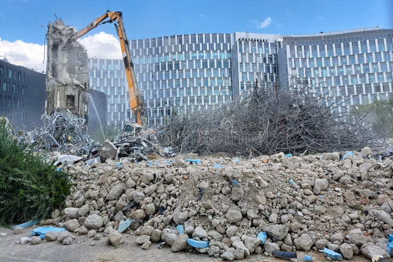 An Excavator Destroys an Old Building. Construction Waste Stock Photo ...