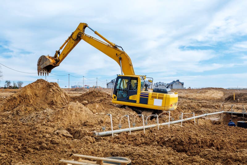 Excavator Dig the Trenches at a Construction Site. Trench for Laying ...
