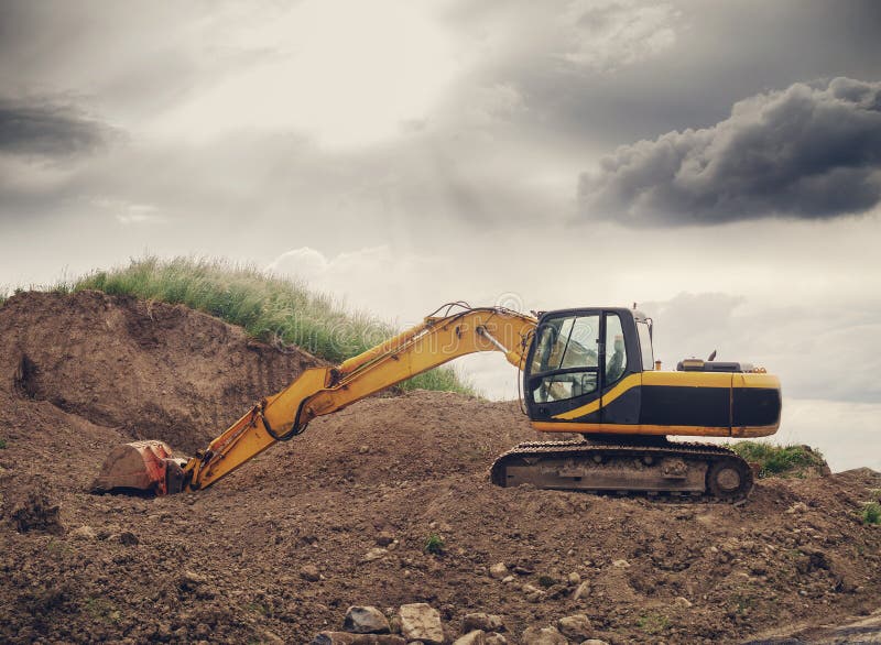 Excavator Digging Pit in the Ground, Dramatic Cloudy Sky, Concept ...