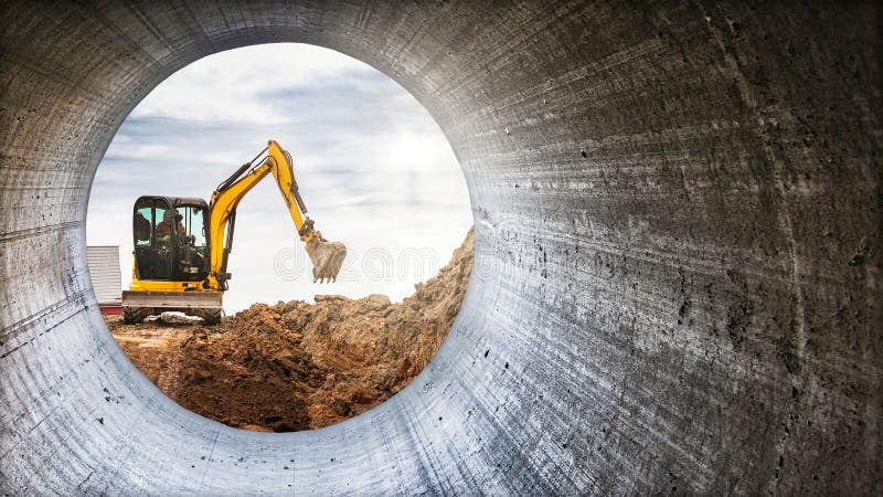 Excavator Digging through Soil in a Large Concrete Pipe at a ...