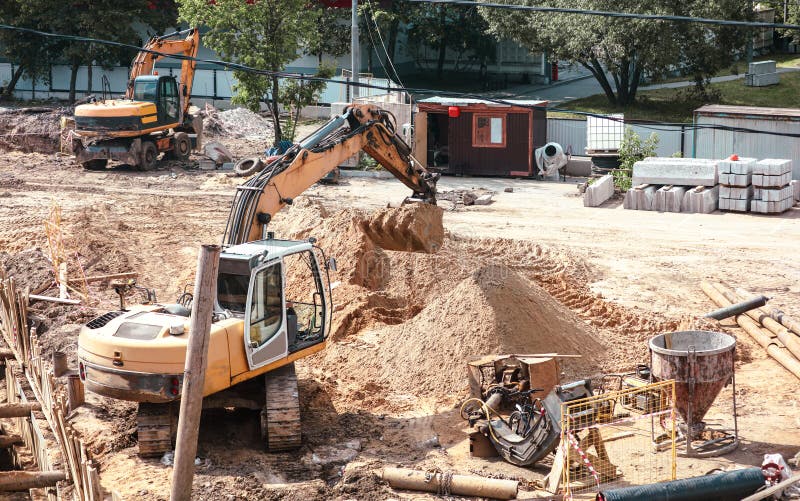 Excavator Digs the Ground at a Construction Site. Stock Photo - Image ...